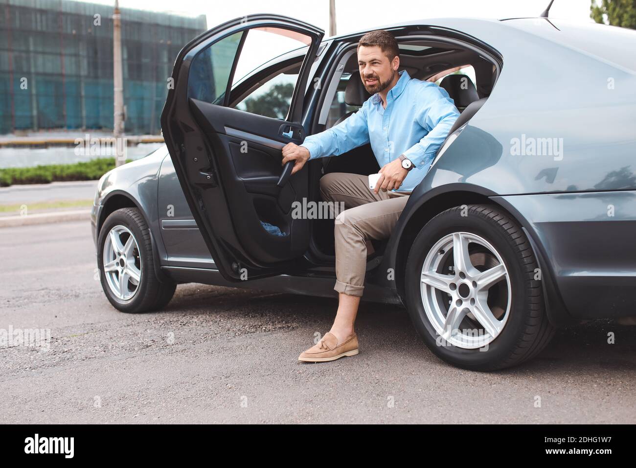 Handsome man getting out of modern car Stock Photo - Alamy