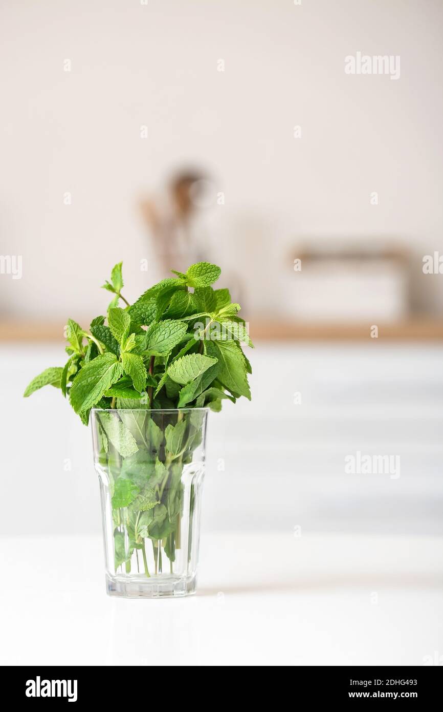 Glass with fresh mint on table in kitchen Stock Photo - Alamy