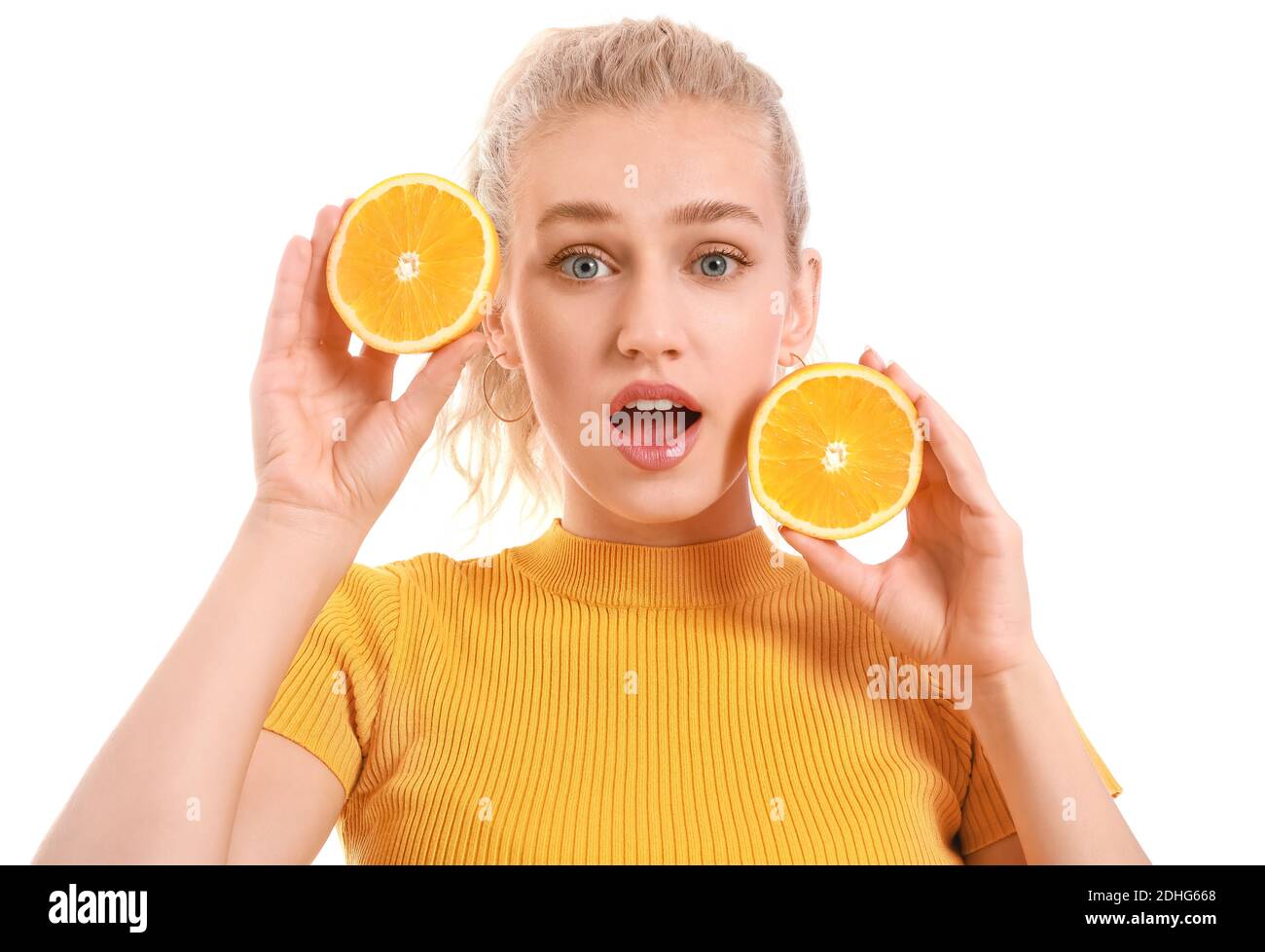 Surprised young woman with orange slices on white background Stock ...