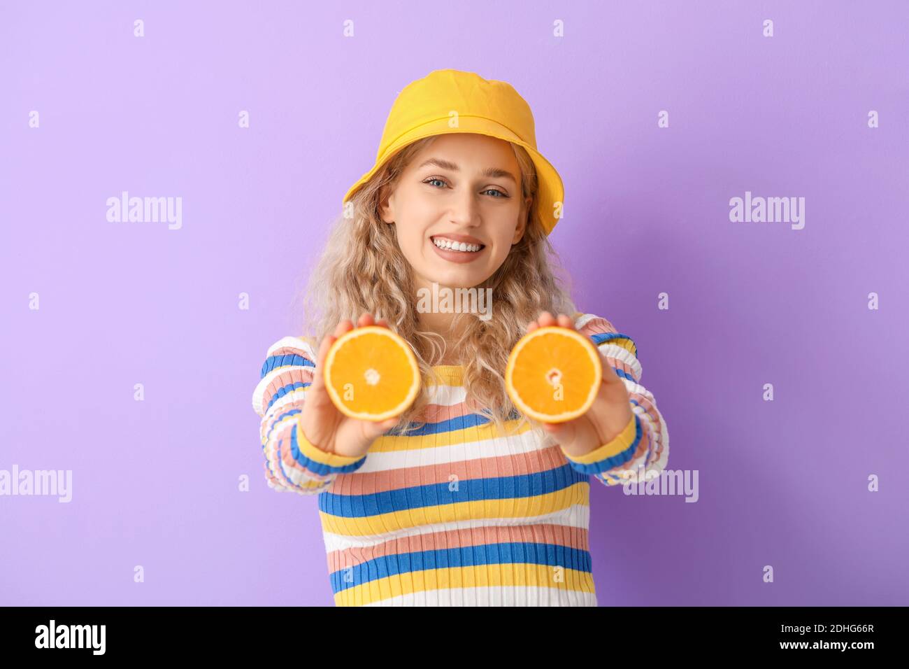 Beautiful young woman with cut orange on color background Stock Photo ...