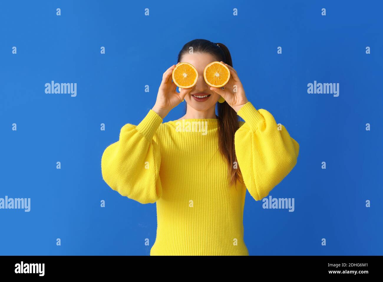 Funny young woman with orange slices on color background Stock Photo ...