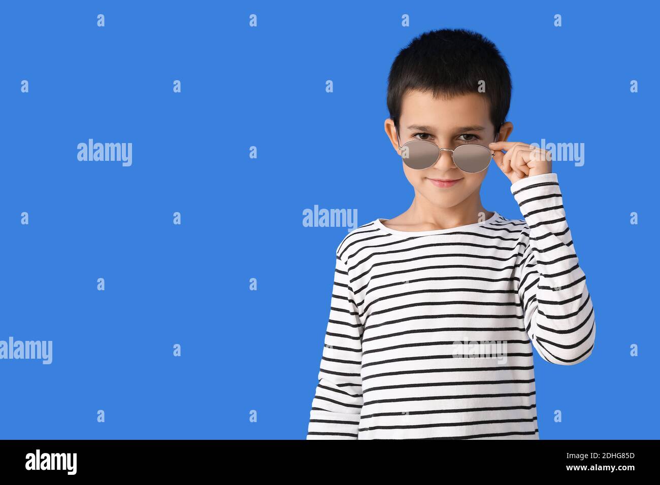 Cute boy wearing stylish sunglasses against color background Stock ...