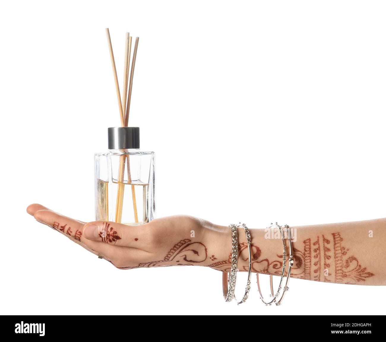 Beautiful female hand with henna tattoo and reed diffuser on white ...
