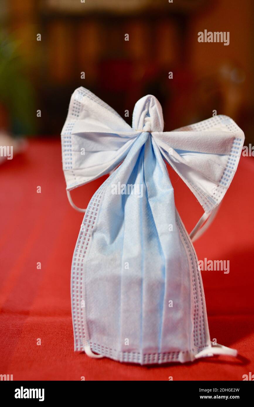 Two surgical masks formed into the crafty shape of an angel with wings ...