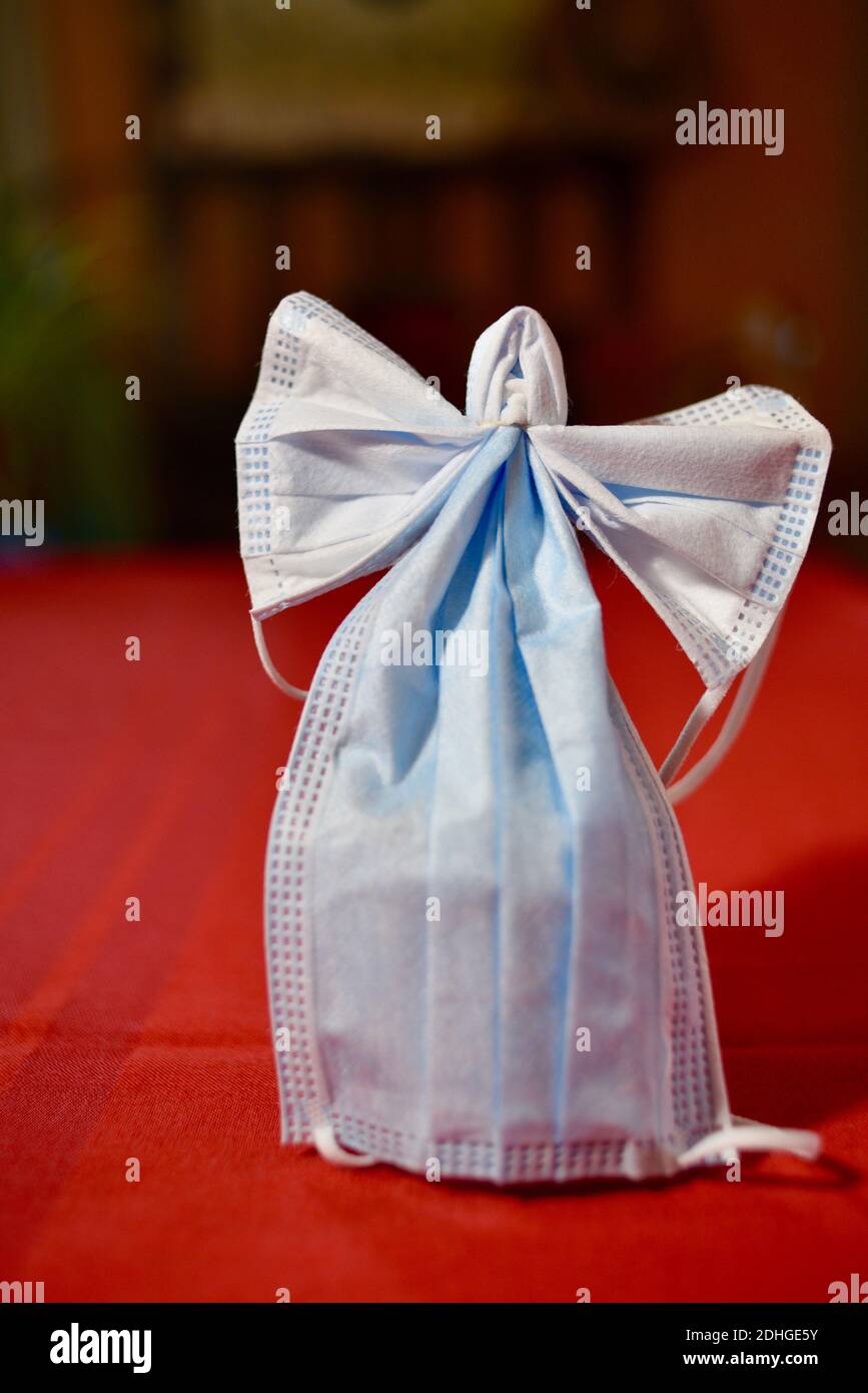 Two surgical masks formed into the crafty shape of an angel with wings ...