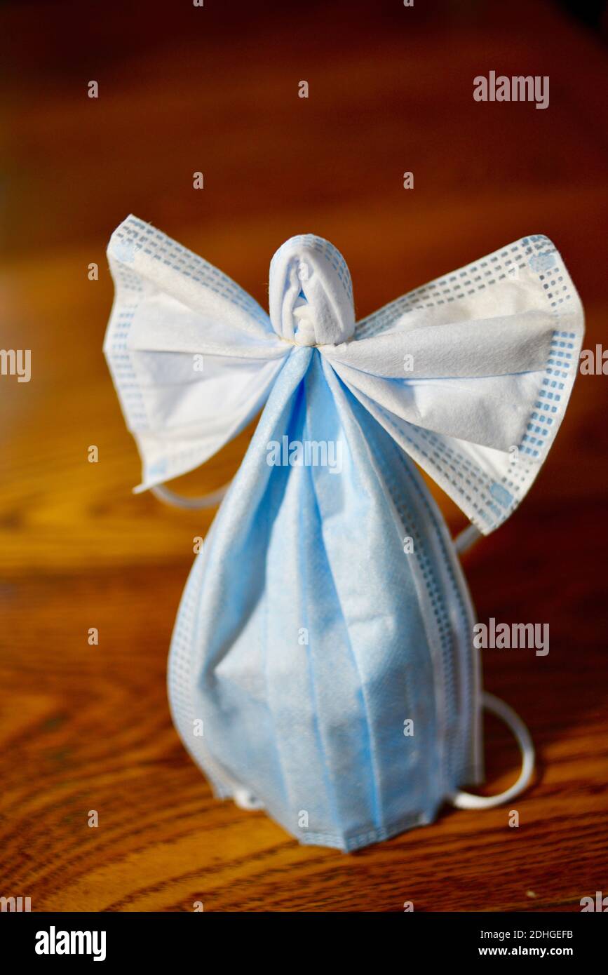 Two surgical masks formed into the crafty shape of an angel with wings ...