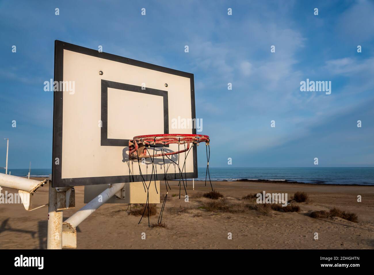 A basketball hoop on the beach under a cloudy sky Stock Photo - Alamy