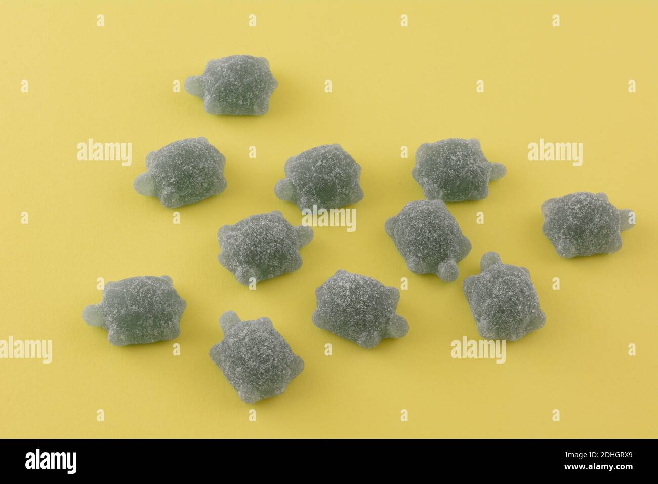 Sour green gummy candy in shape of turtle on yellow background Stock ...
