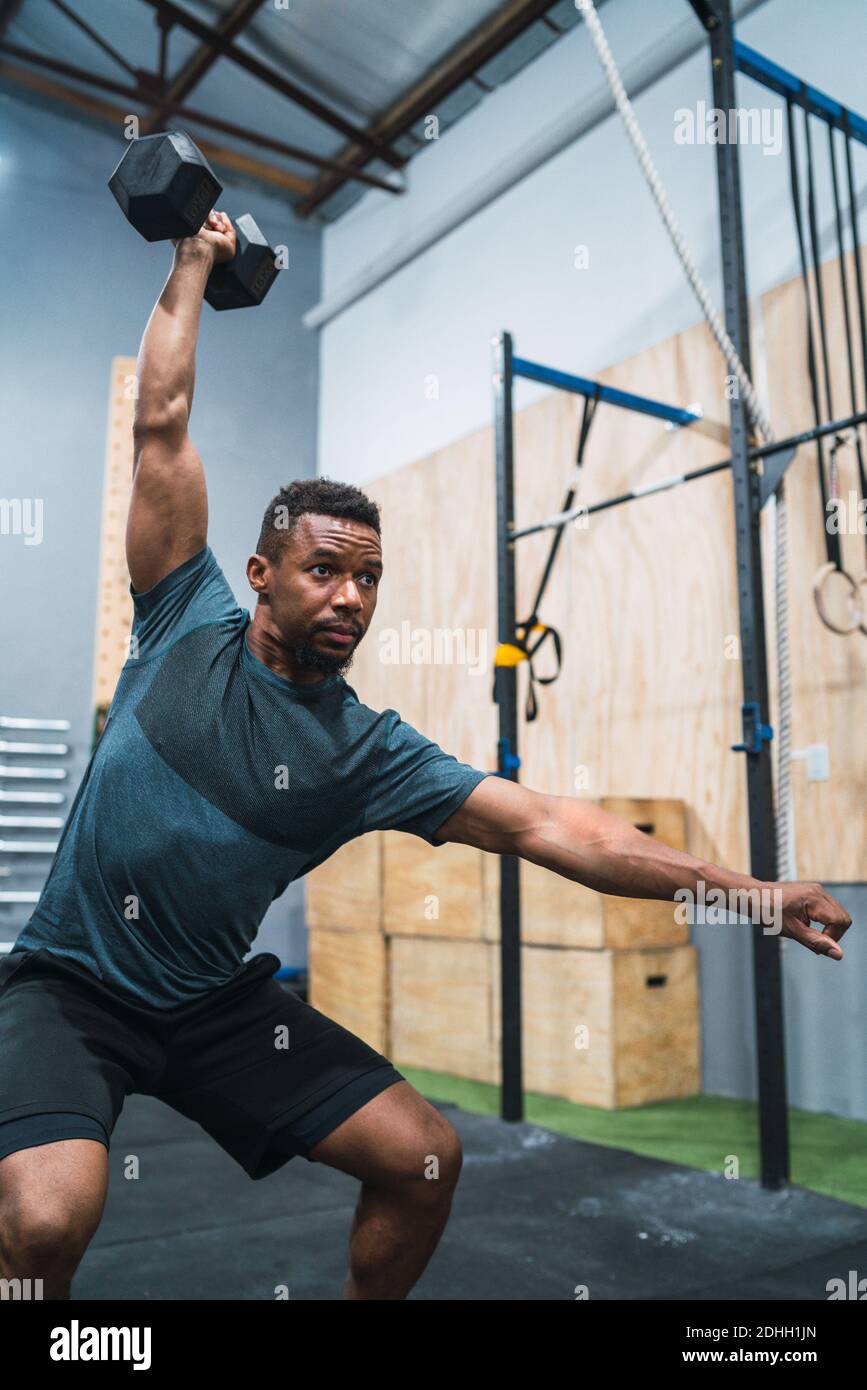 Crossfit athlete doing exercise with dumbbell Stock Photo - Alamy