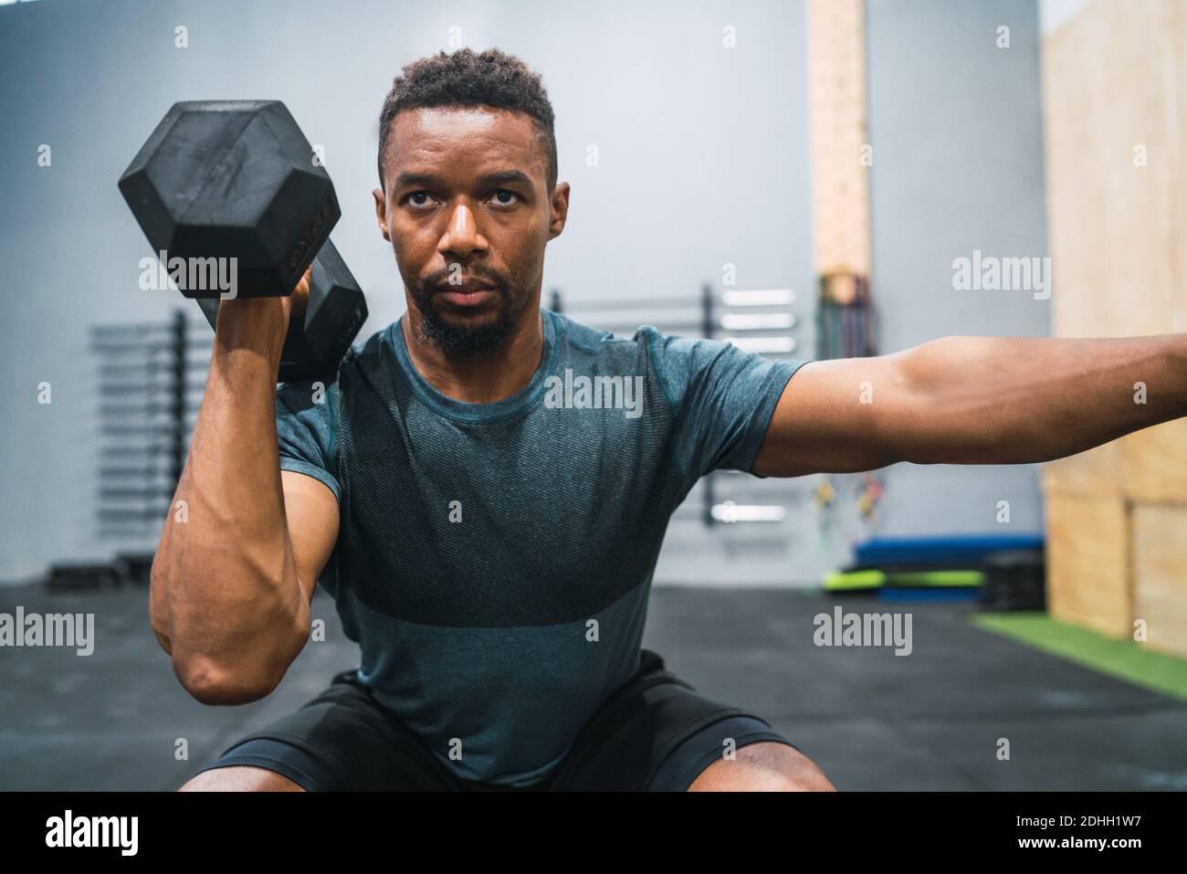 Crossfit athlete doing exercise with dumbbell Stock Photo - Alamy