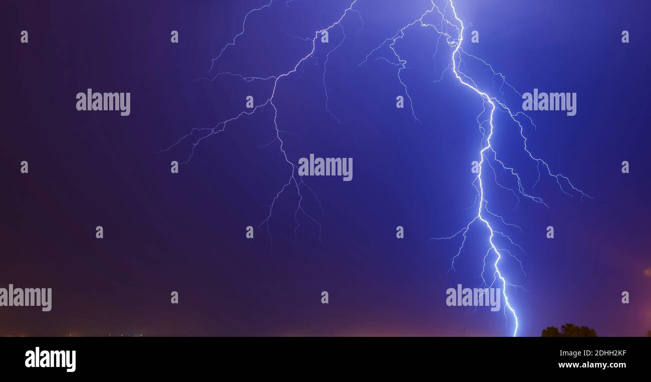 A mesmerizing shot of large lightning strike to ground Stock Photo - Alamy