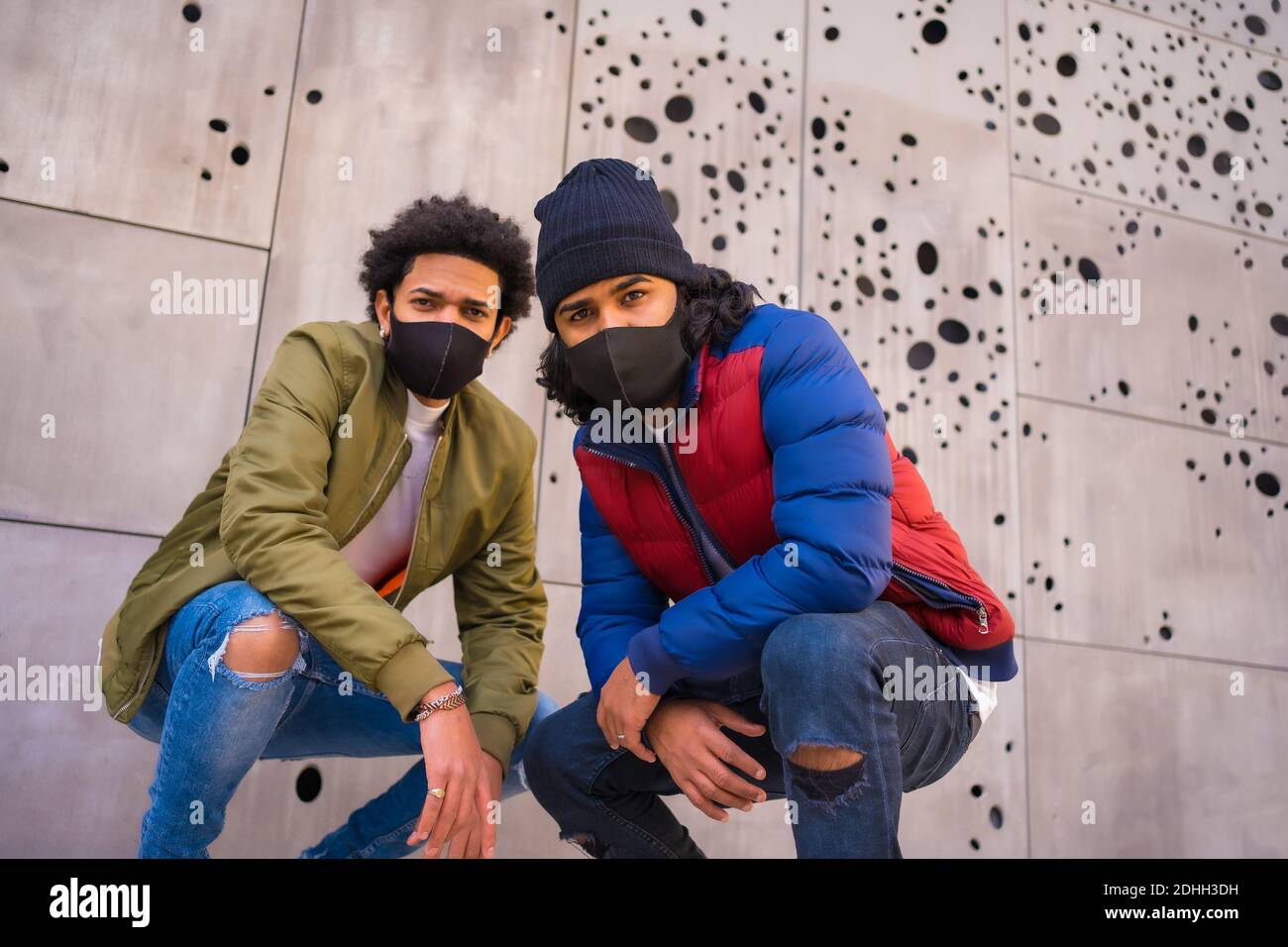 Two Latin men in masks posing near a wall Stock Photo - Alamy
