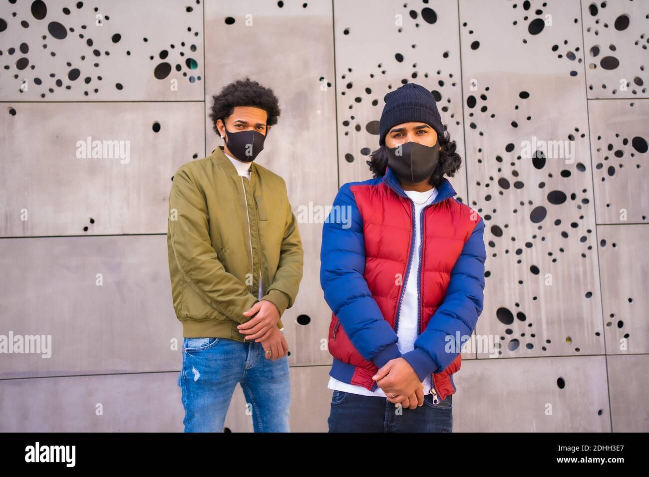Two Latin men in masks posing near a wall Stock Photo - Alamy