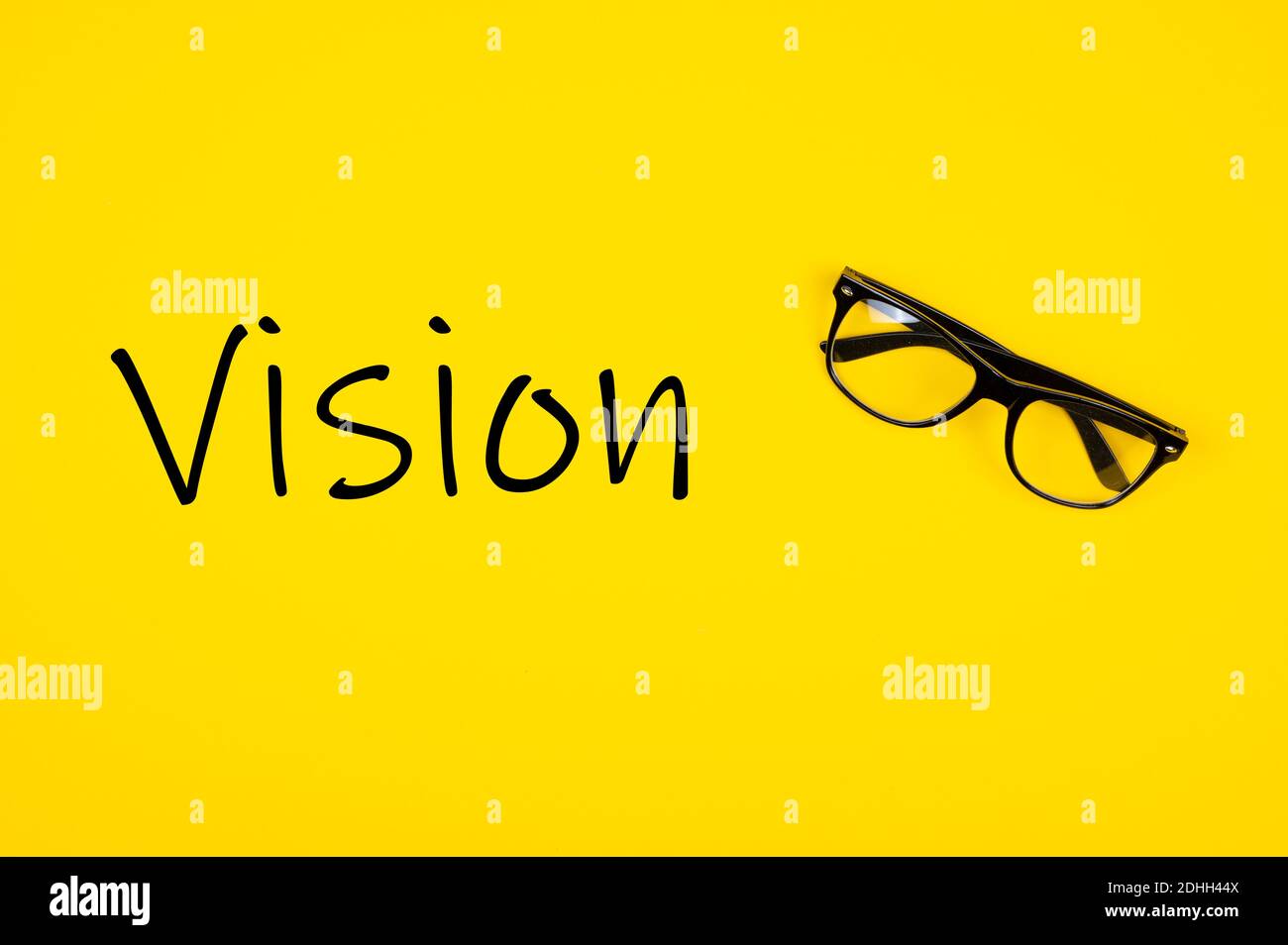 A top view of vision written on yellow background with glasses Stock ...