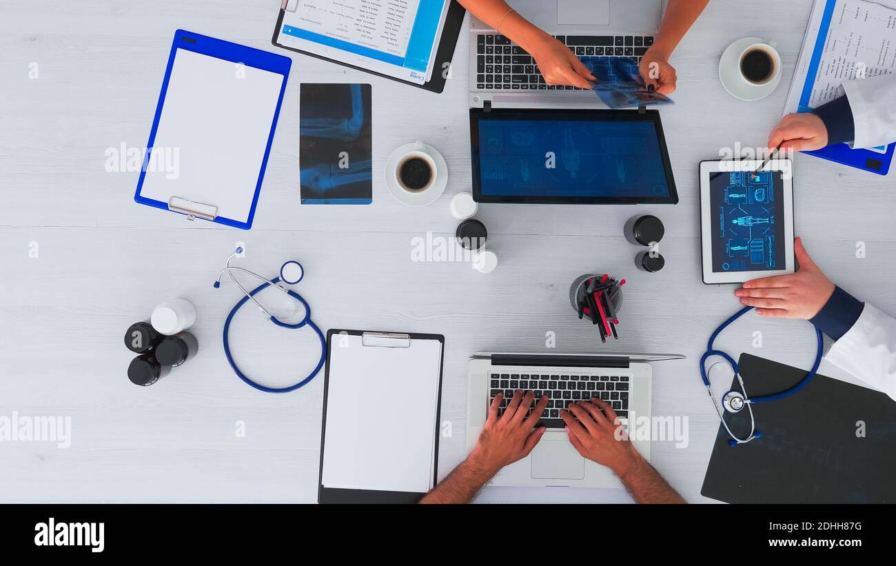 Team of physicians discussing diagnosis for patient in medical office ...