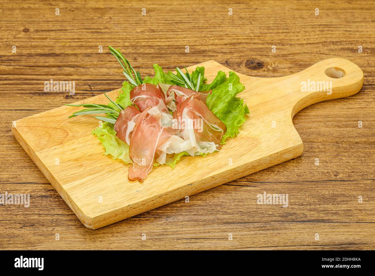 Sliced pork Jamon meat with rosemary Stock Photo - Alamy
