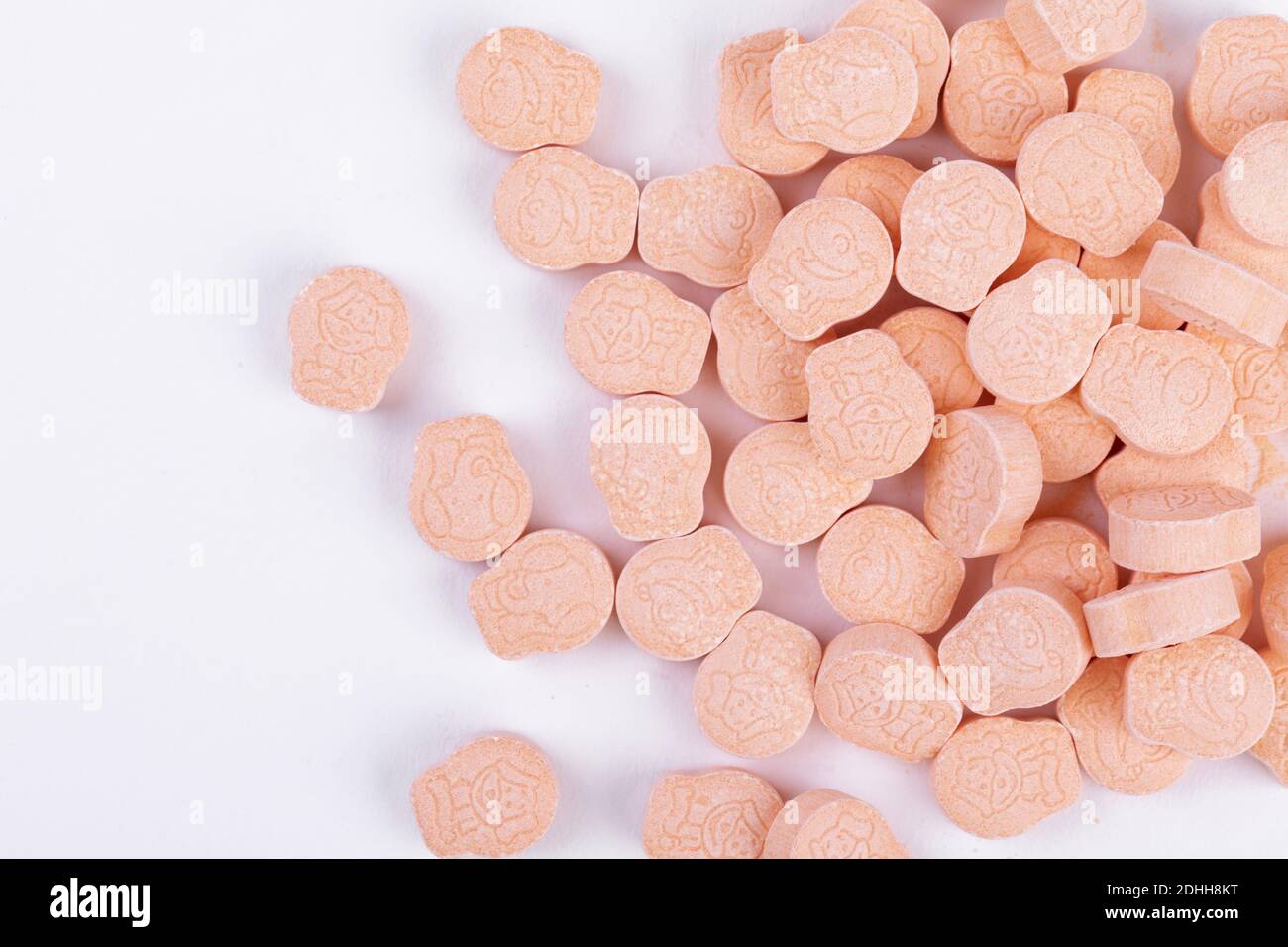 A top view of animal drawings on pink ecstasy pills isolated on white ...