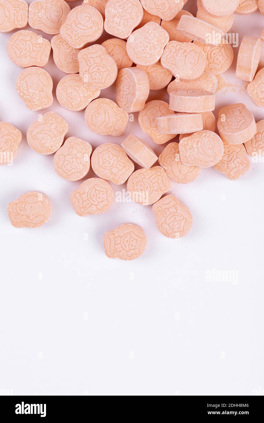 A top view of animal drawings on pink ecstasy pills isolated on white ...