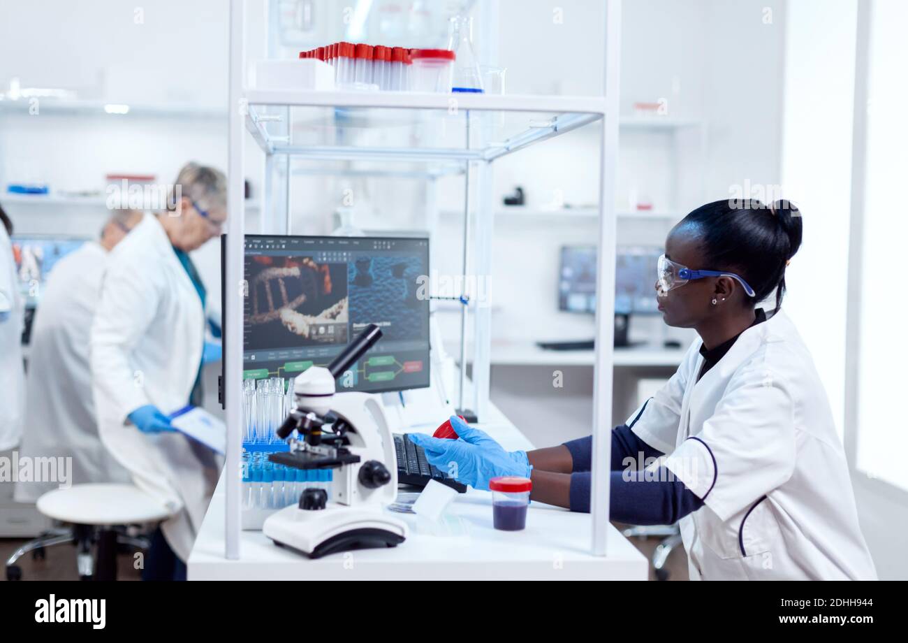 Scientist with african ethnicity conducting virus analysis with her ...