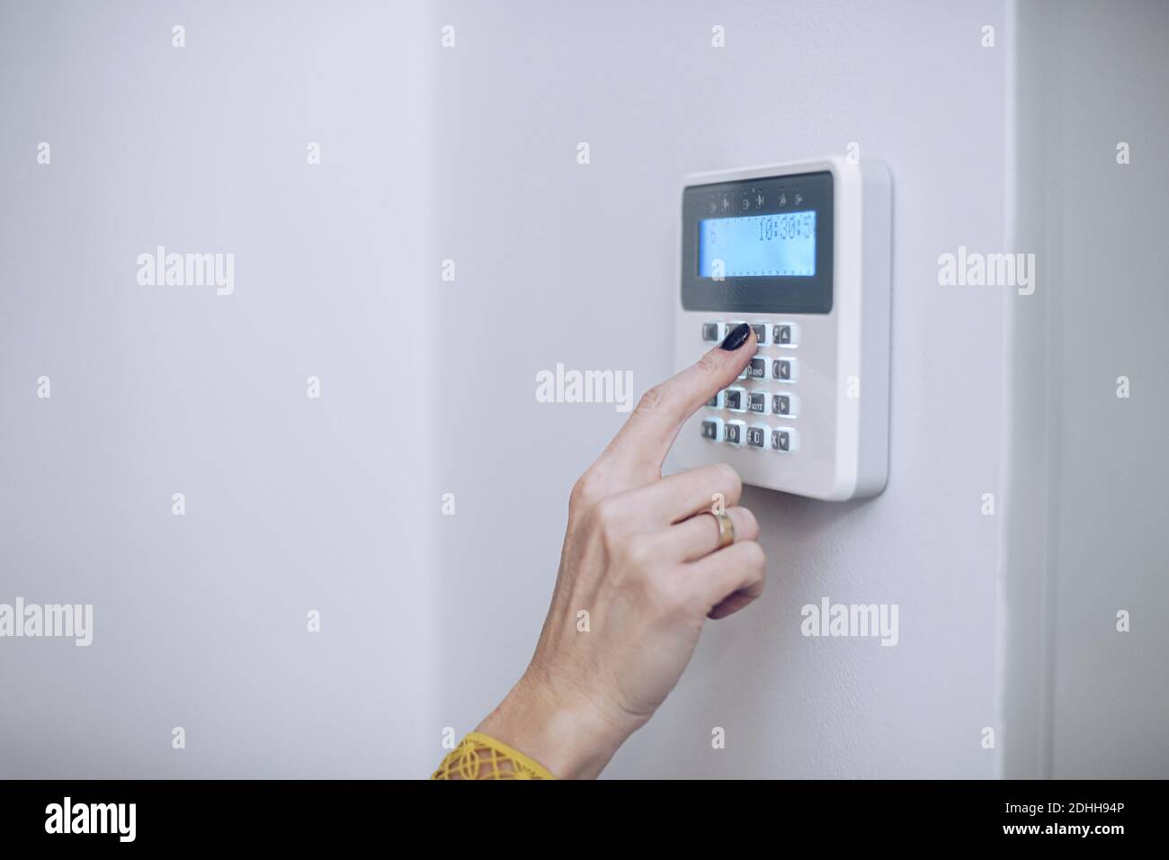 Security home system. Woman entering secret code on home alarm Stock ...