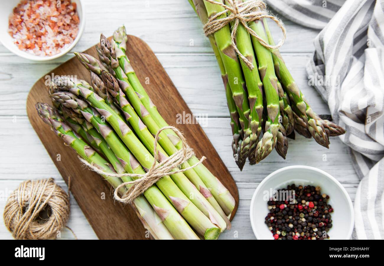 Bunch of raw asparagus stems with different spices and ingredients on ...