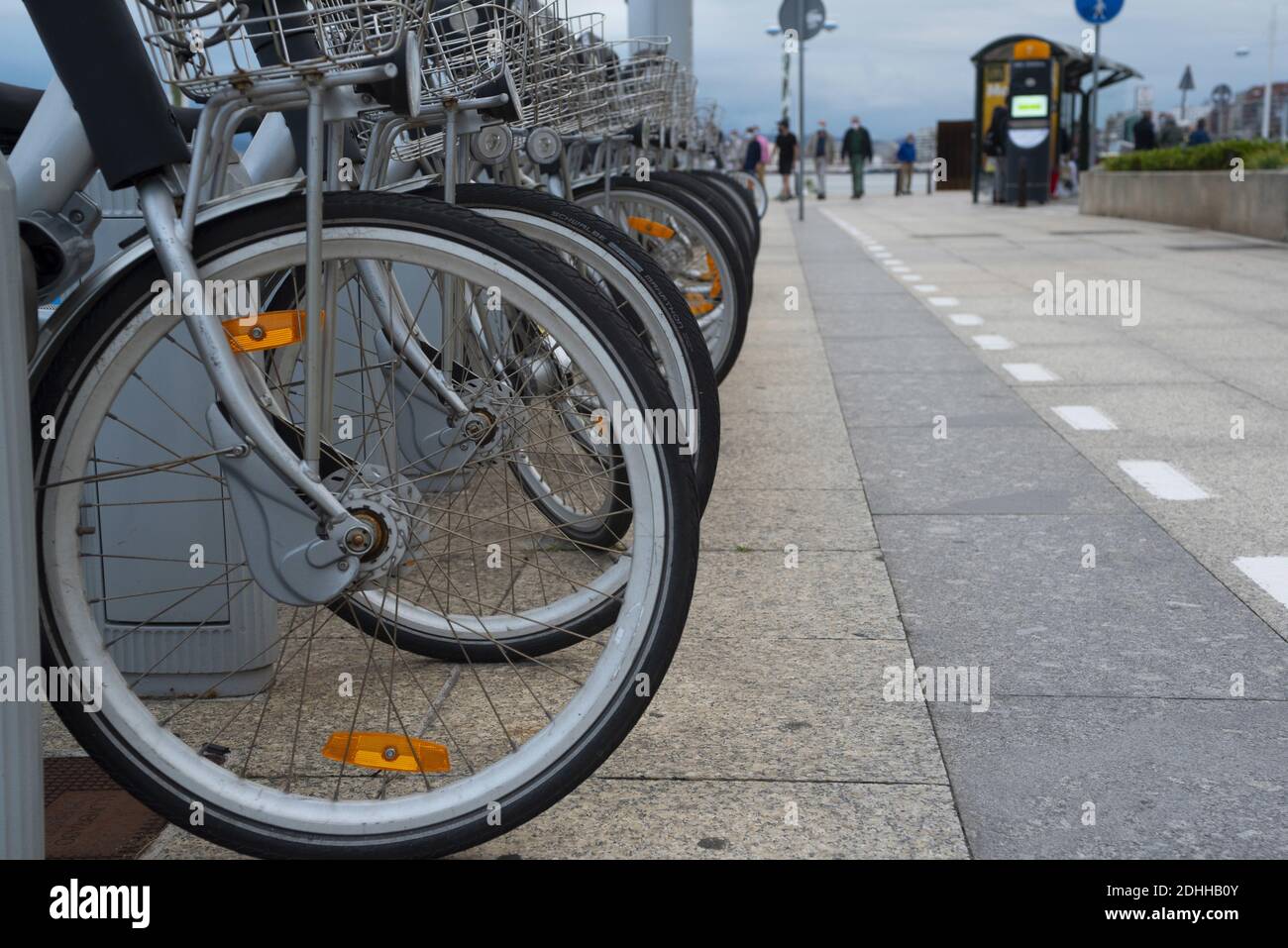 A closeup of bicycles with baskets on a public bicycle rack outdoors ...