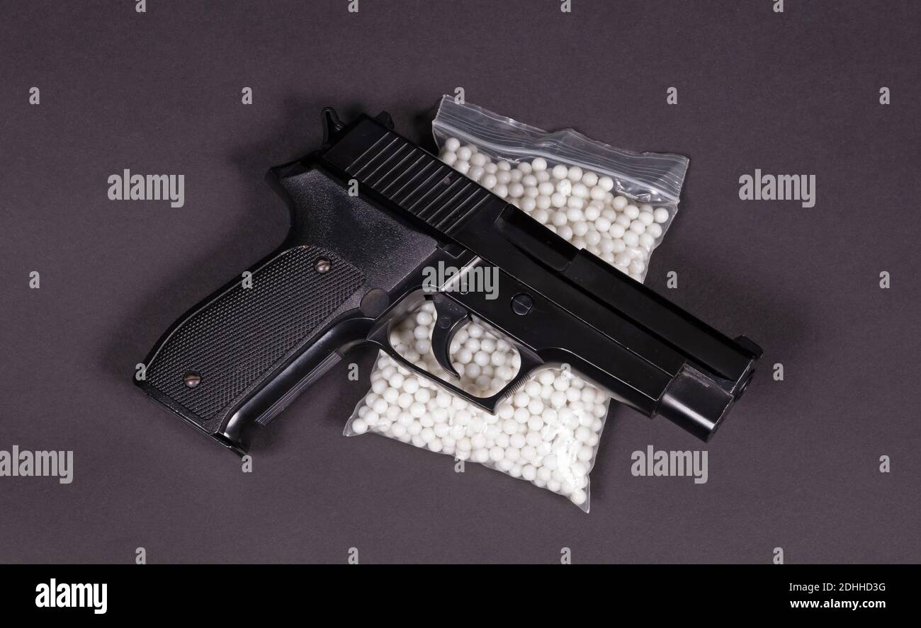 Airsoft pistol with bb bullets on dark background Stock Photo - Alamy