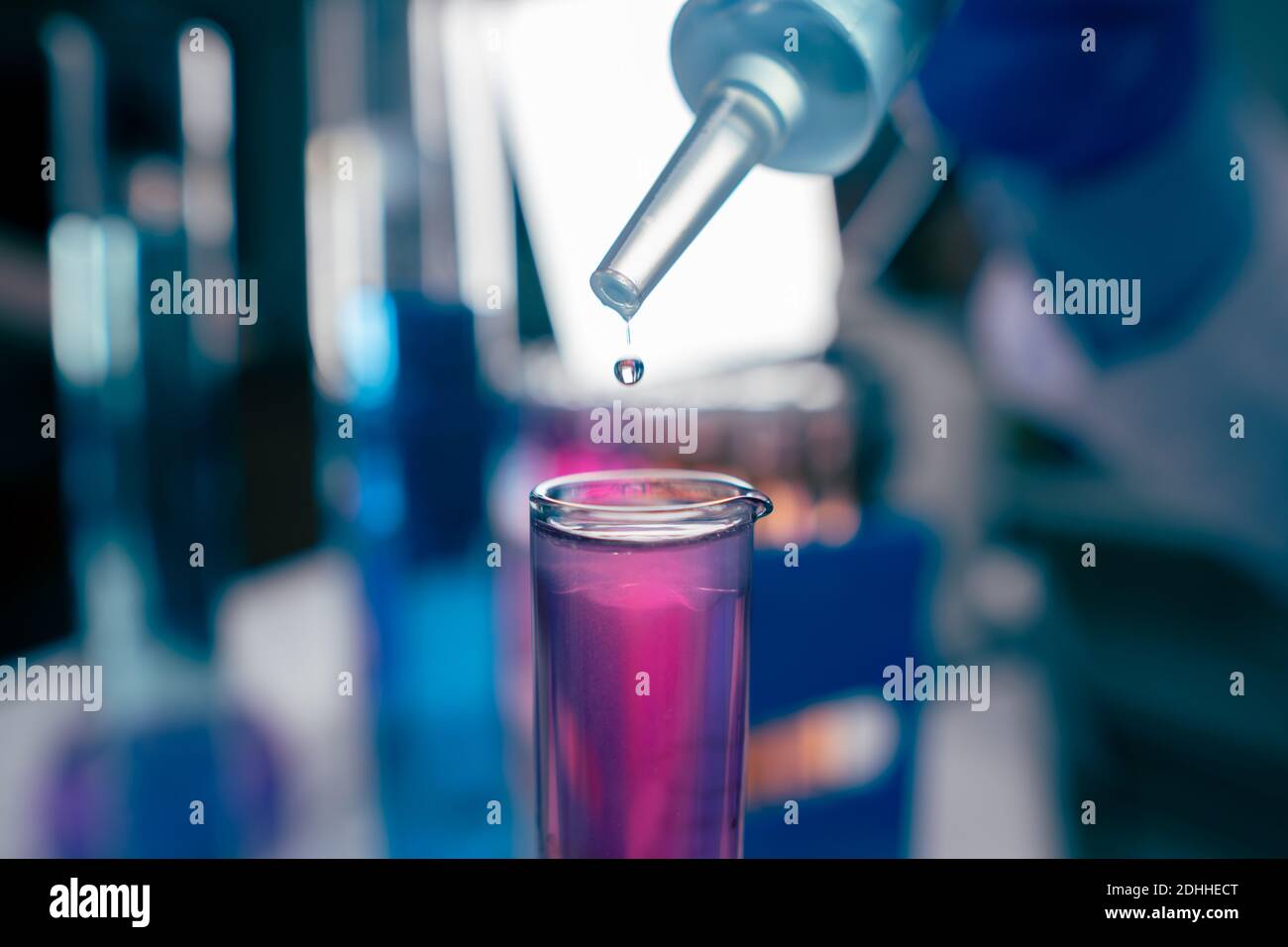 Liquid drop falling into test tubes Stock Photo - Alamy