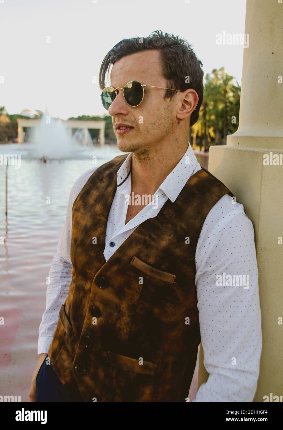 A vertical shot of a male wearing formal attire while standing on a ...