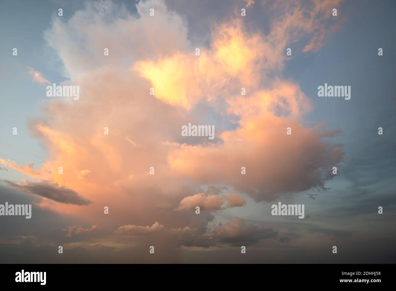 Dramatic moody sunset landscape with puffy clouds lit by yellow setting ...