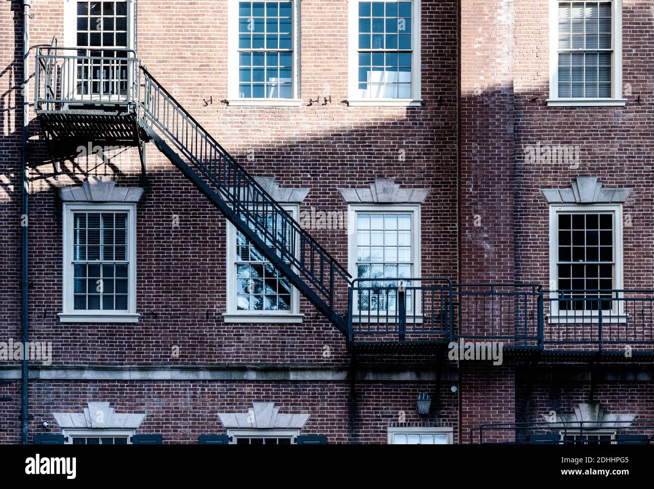 A metal fire escape on a brick building with lots of windows Stock ...