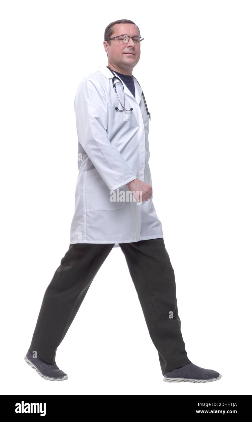 side view. male doctor with a stethoscope confidently walking forward ...