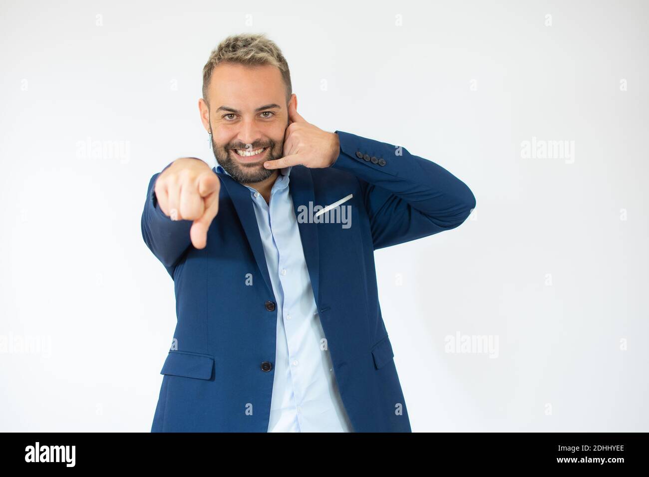 Young man smiling wearing suit making call gesture over white ...