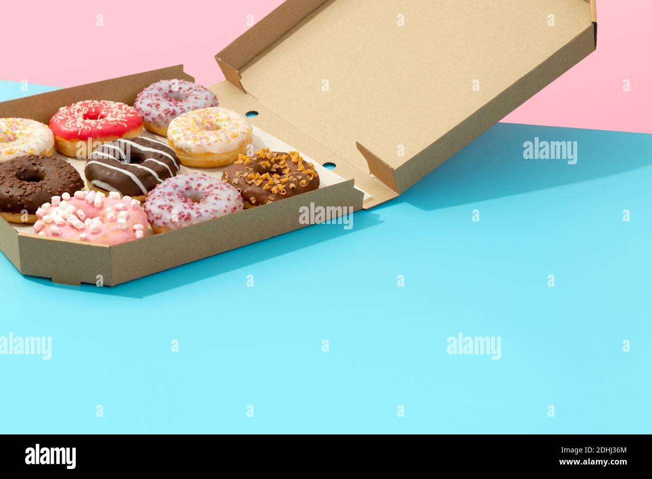 Set of yummy colorful donuts in paper box on blue background. Online ...