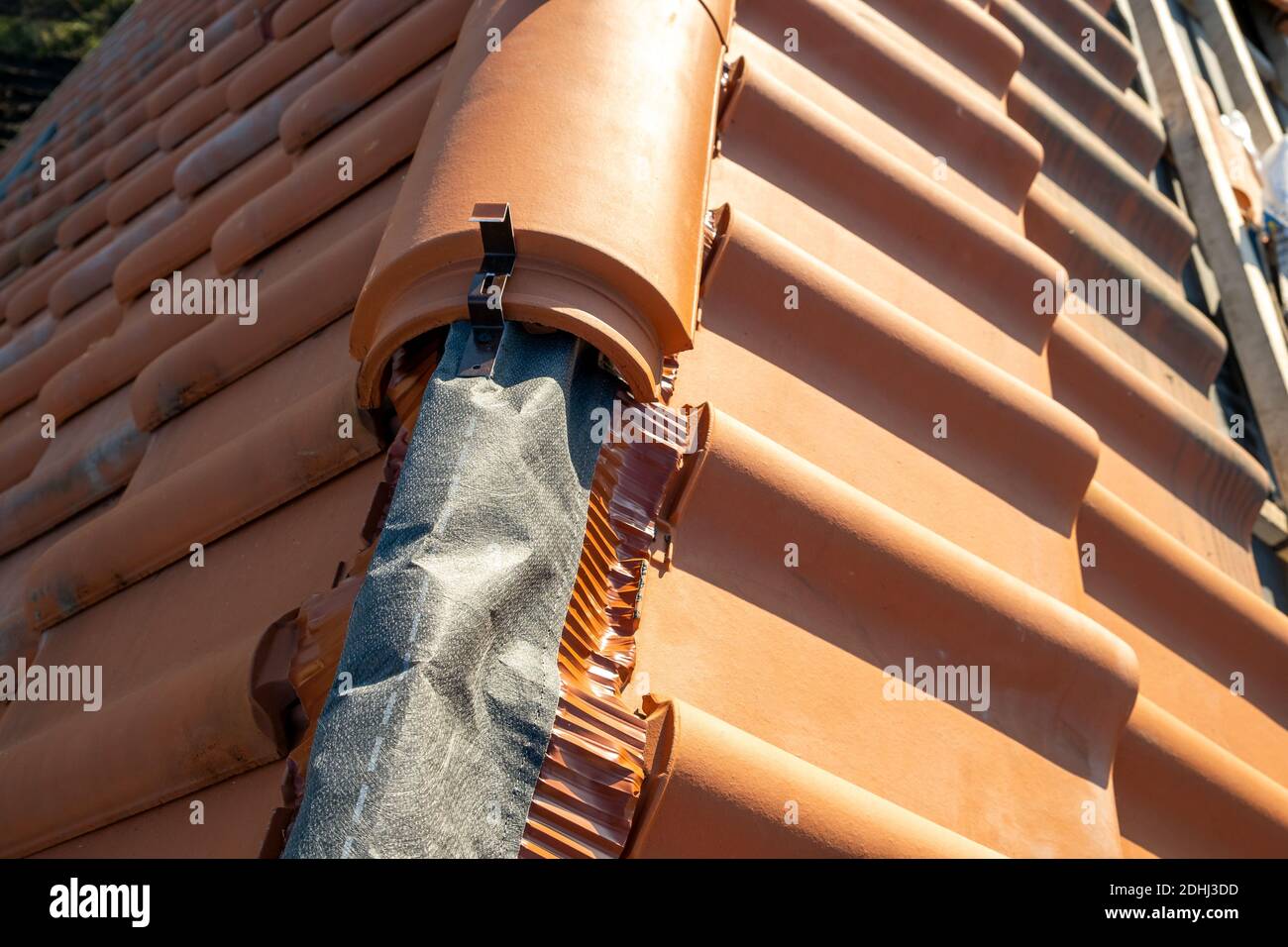 Closeup of yellow ceramic roofing ridge tiles on top of residential ...
