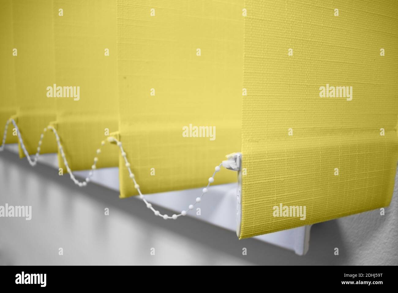 Modern trendy illuminating yellow vertical blinds on the window of the ...