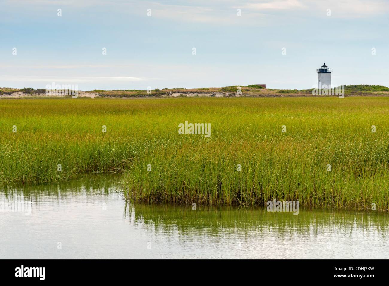 A view of the saltwater marshes with grasslands and Wood End lighthouse ...