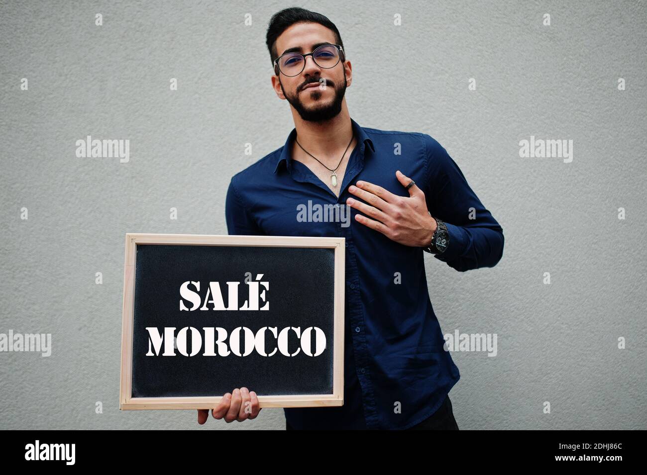 Arab man wear blue shirt and eyeglasses hold board with Sale Morocco ...