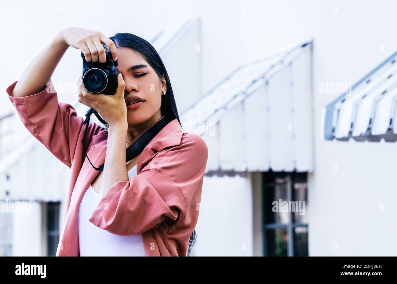 A shot of a young woman photographer with a camera - shooting process ...
