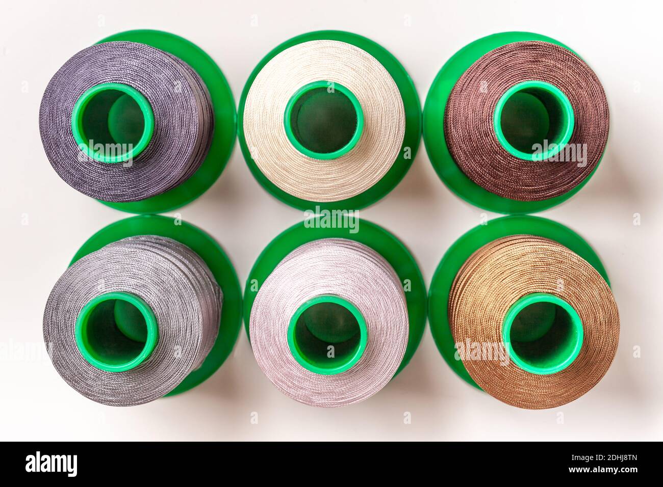 Set of big bobbin and skeins of thread different colors on white ...