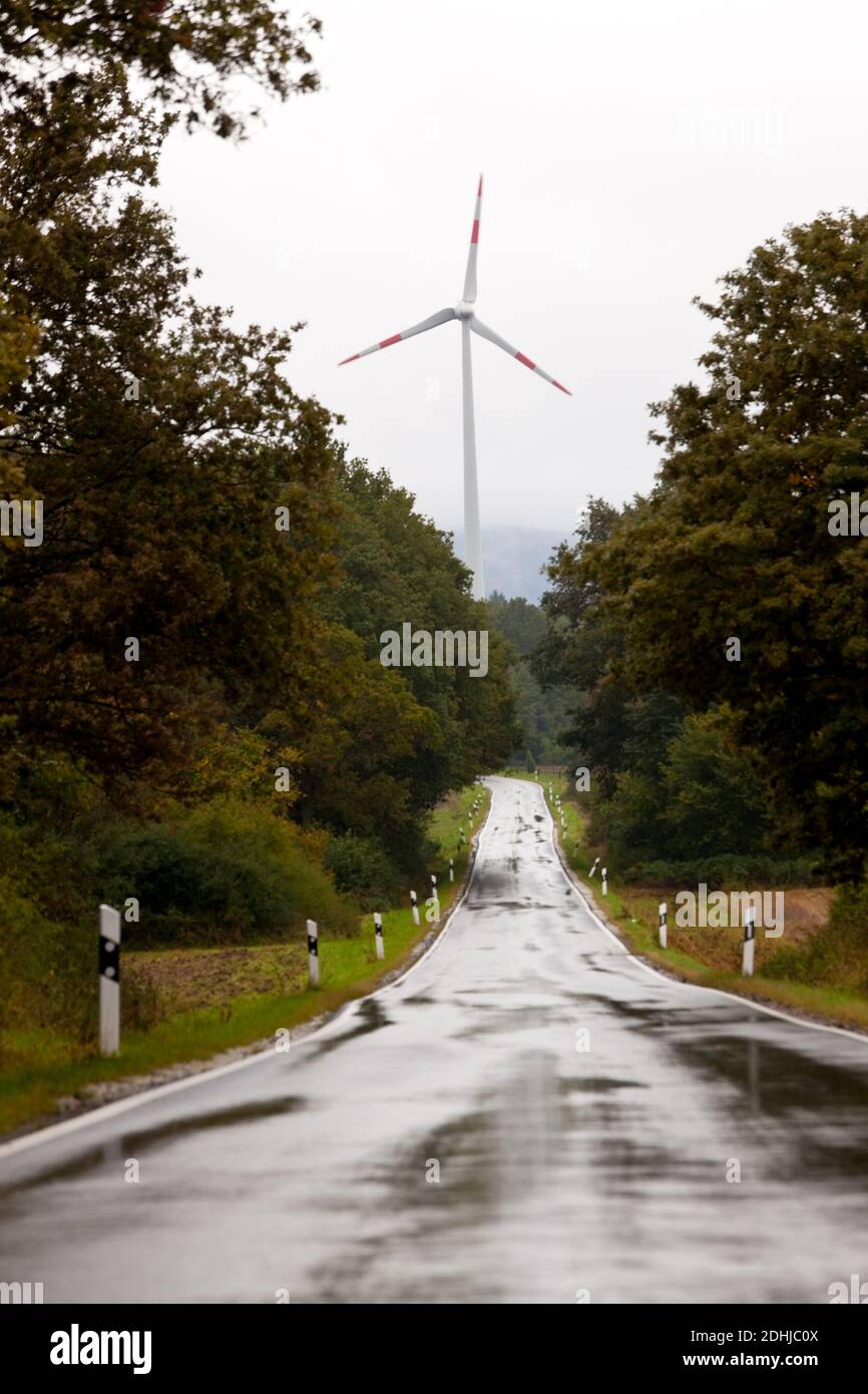 Wind turbine and wet straight road nr Trier, in the Moselle wine region ...