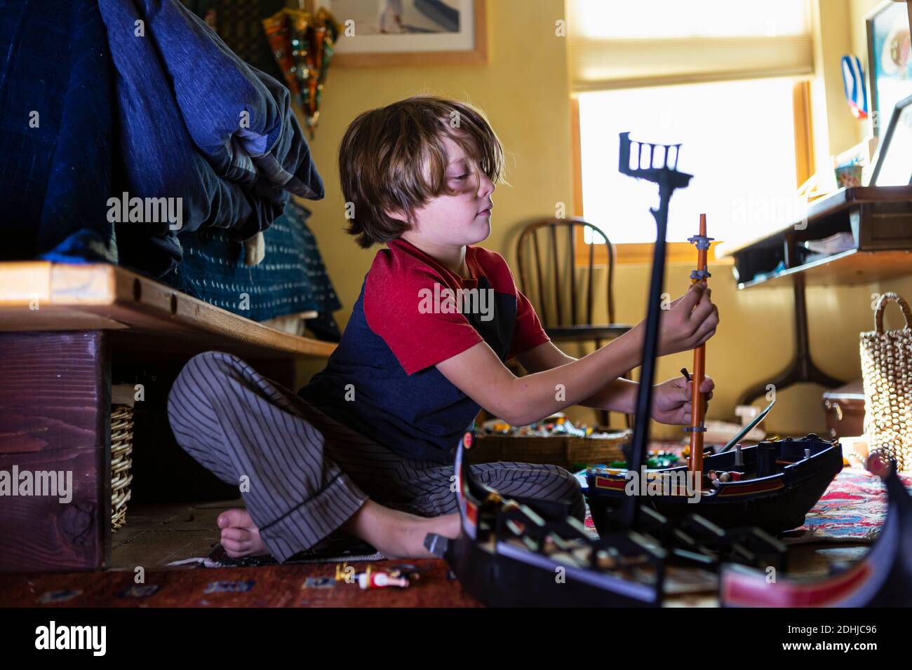 7 year old boy playing with his toys in his room Stock Photo - Alamy