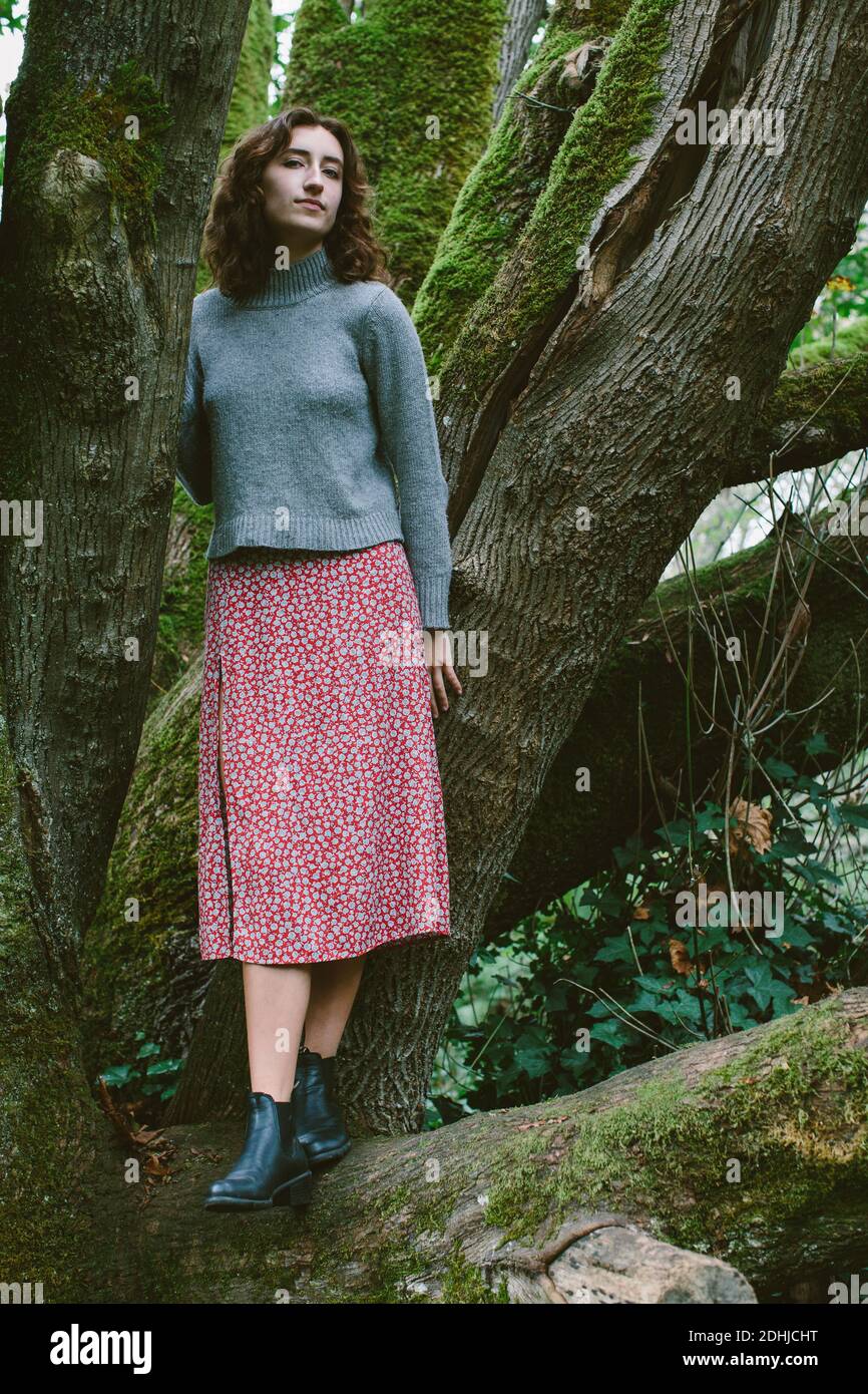 Portrait of seventeen year old girl standing in front of of moss ...