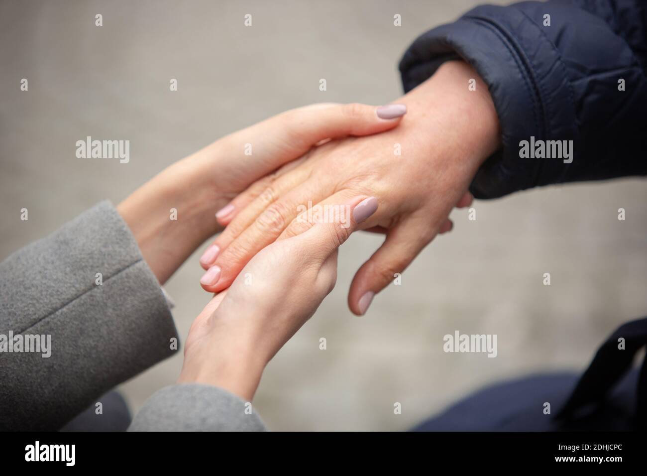 Female healthcare worker holding hands of senior woman during the walk ...