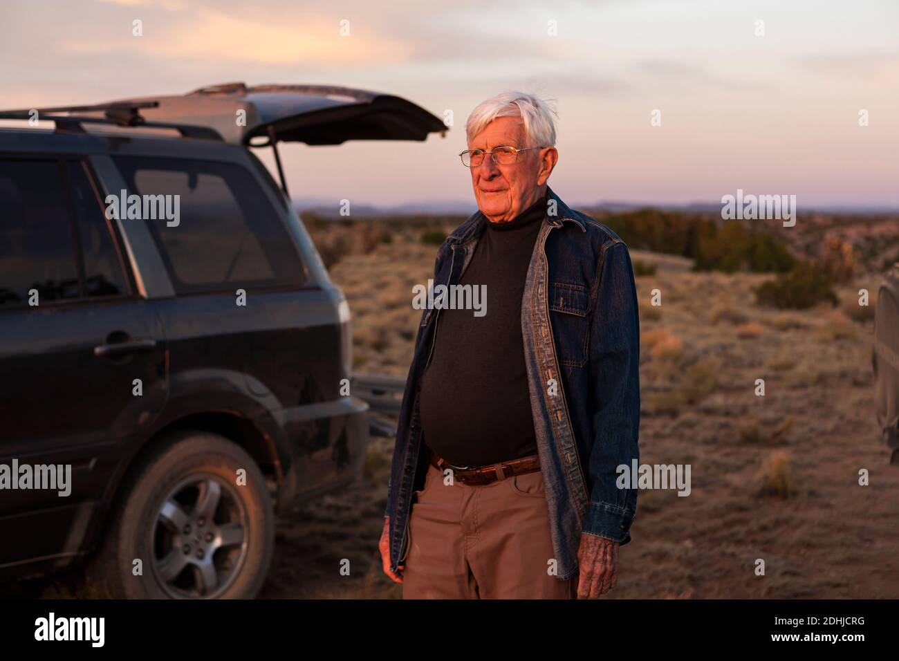 senior man between SUV's at sunset, Galisteo Basin, Santa Fe, NM Stock ...
