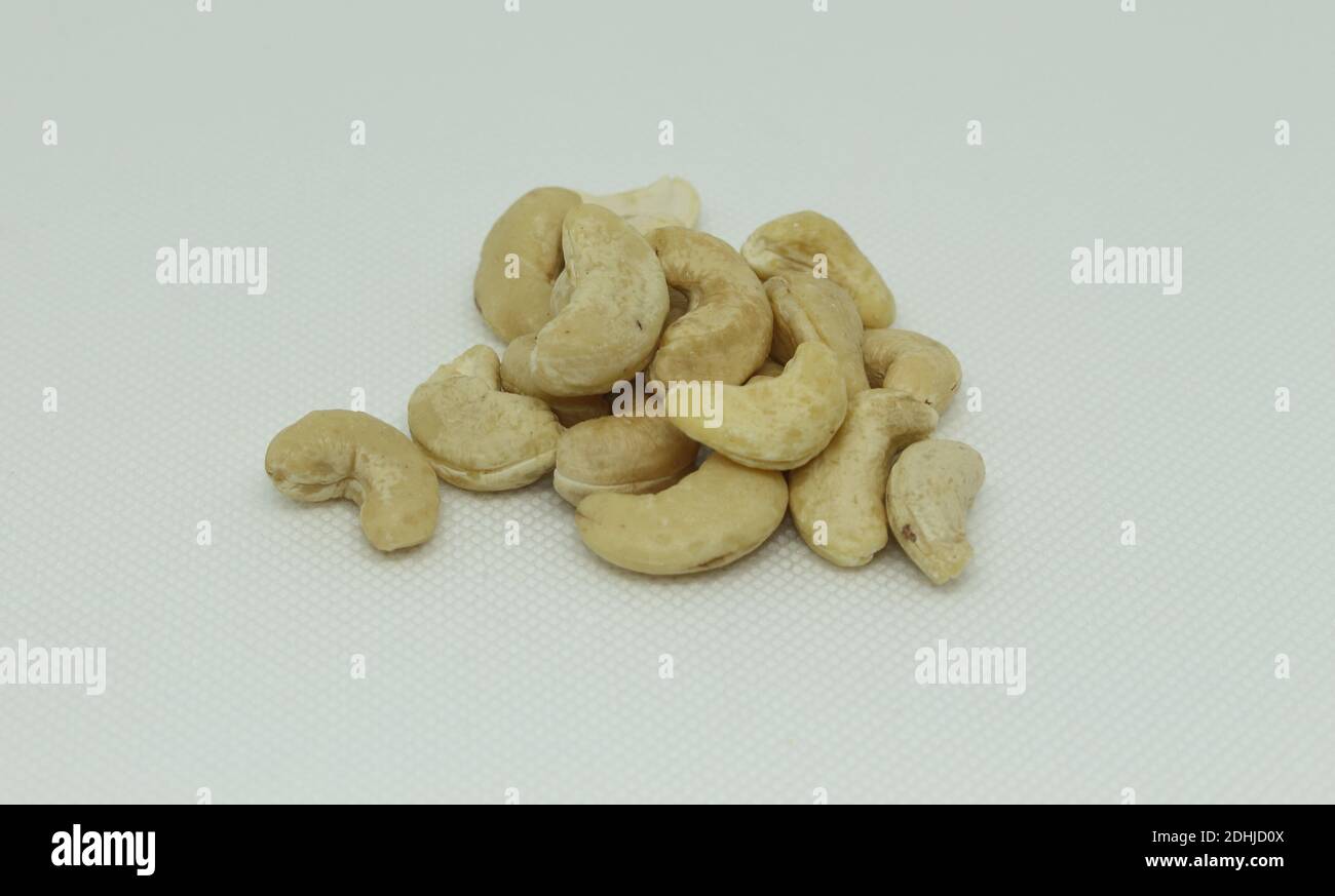 A closeup of dried cashew nuts on a white surface Stock Photo - Alamy