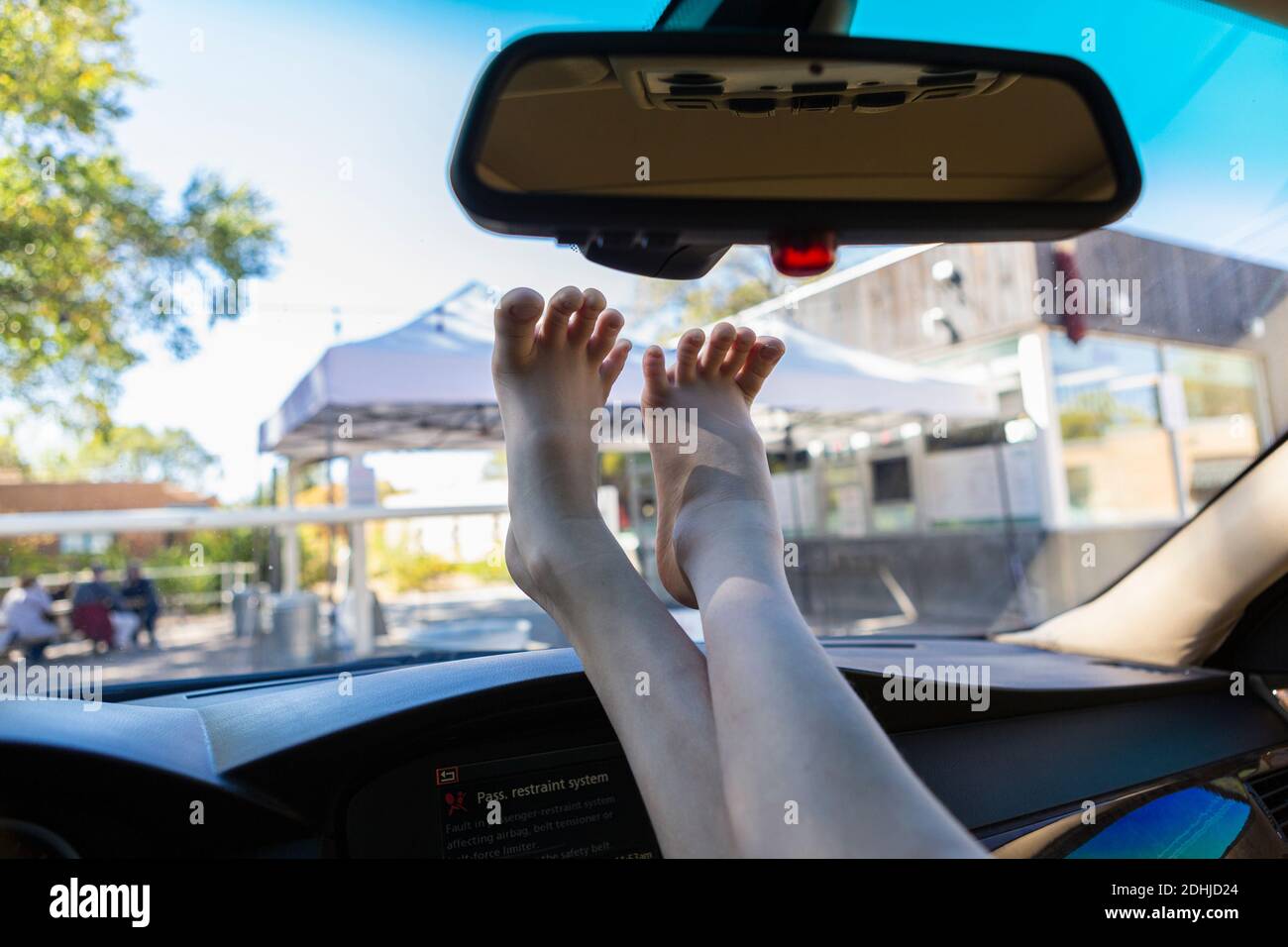 Young boy's bare feet resting on dashboard of car Stock Photo - Alamy