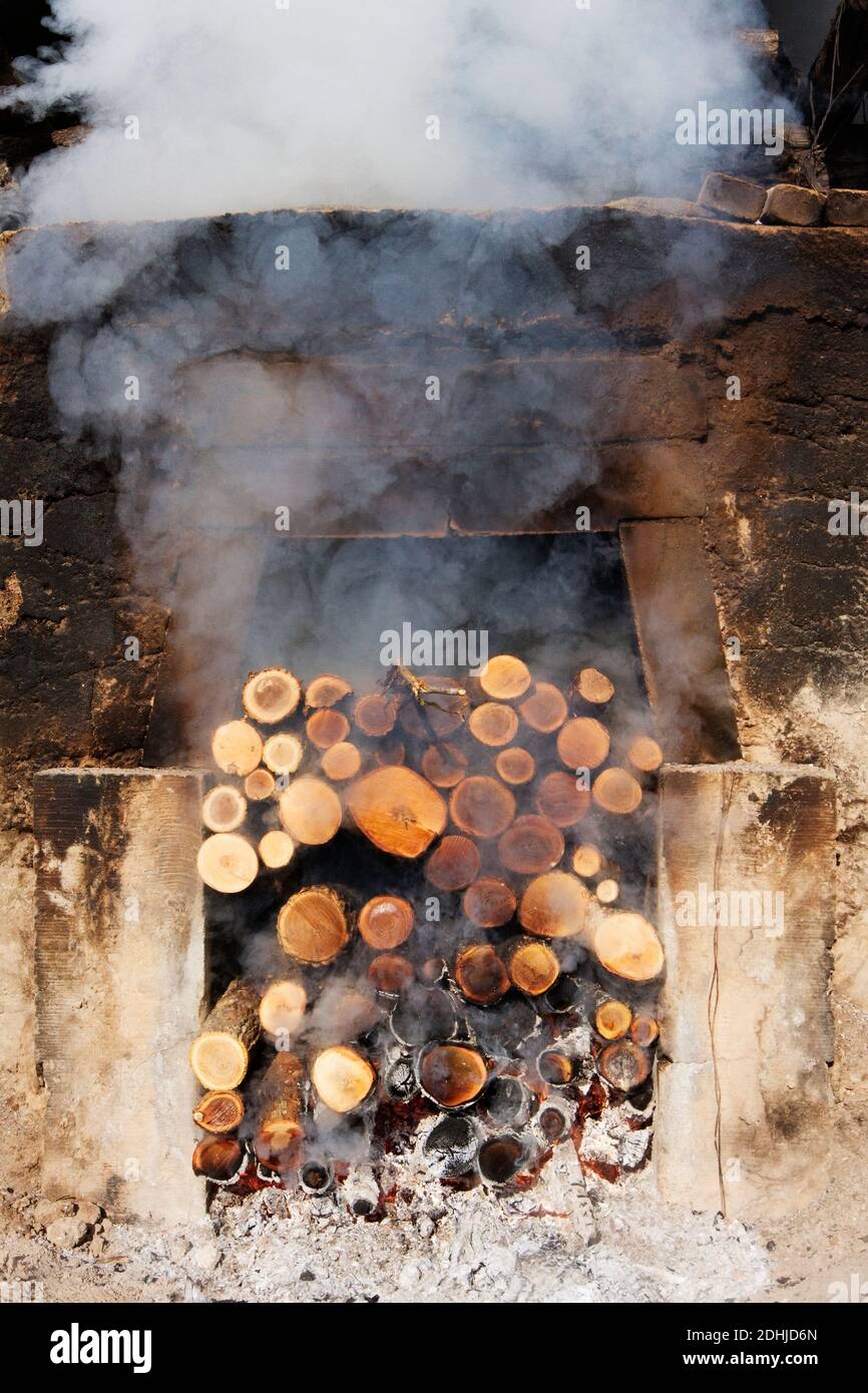 Smoking pile of logs in open fireplace Stock Photo - Alamy