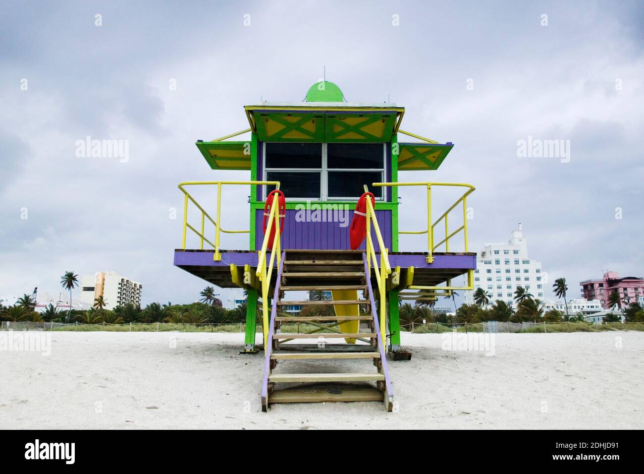 Wooden colourful lifeguard hut on a sandy beach with high rise ...