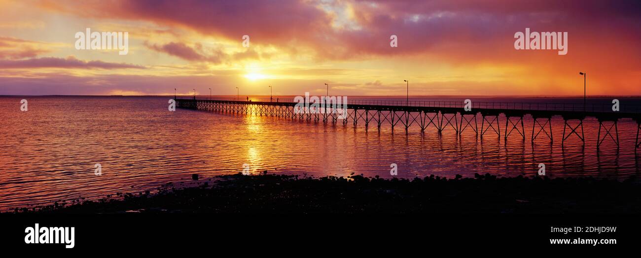 Pier in the sea with sunset on the horizon of the ocean Stock Photo - Alamy